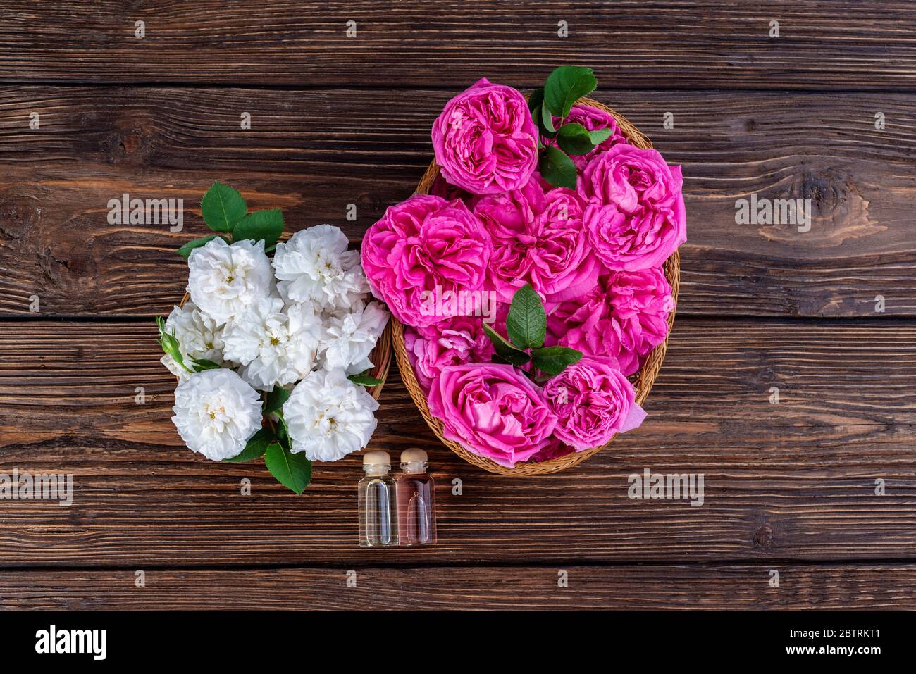 Pink and white Damask roses in basket with vials of rose essence Stock ...