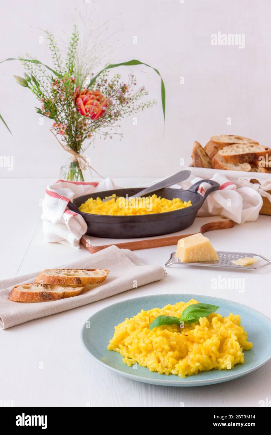 Risotto Milanese, wooden table with traditional Italian saffron risotto ...