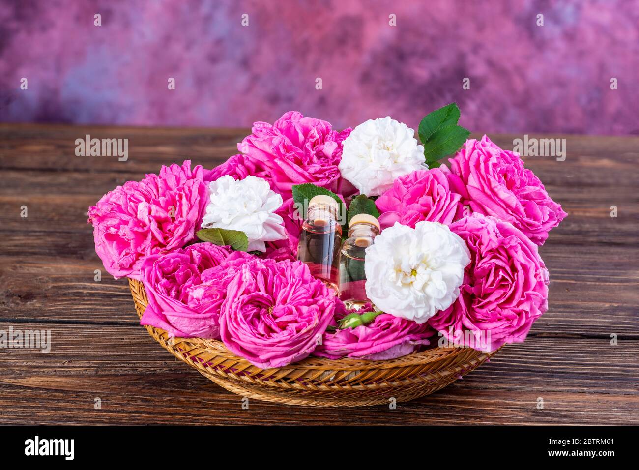 Pink and white Damask roses in basket with vials of rose essence Stock ...