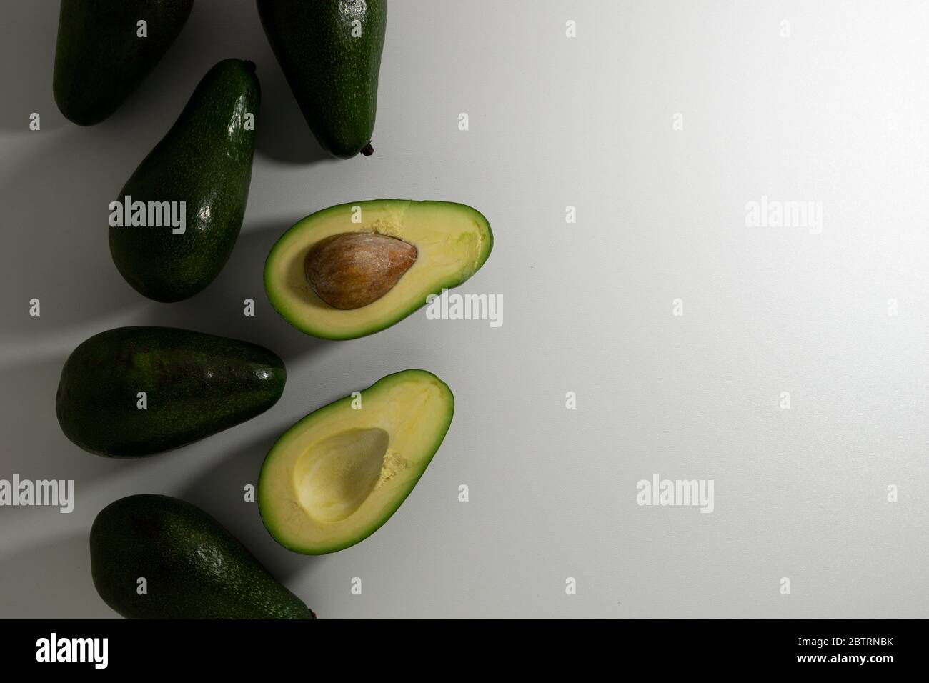 Ripe avocado fruits whole and sliced on a white background. Top View ...