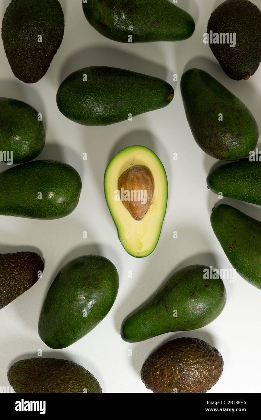 Whole and sliced avocado fruits with a visible core in the center. Top ...