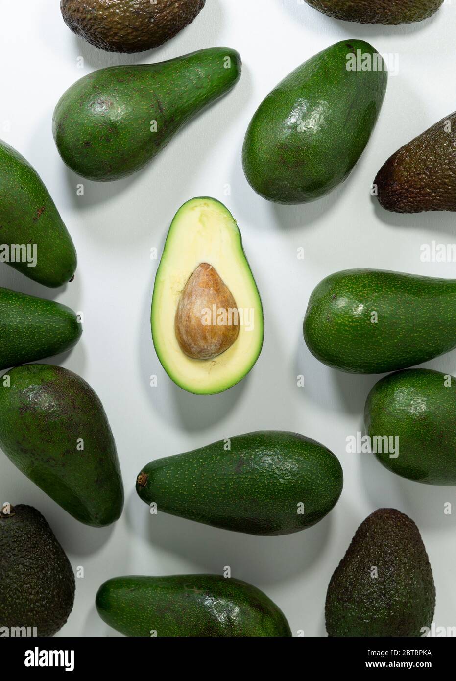 Whole and sliced avocado fruits with a visible core in the center. Top ...
