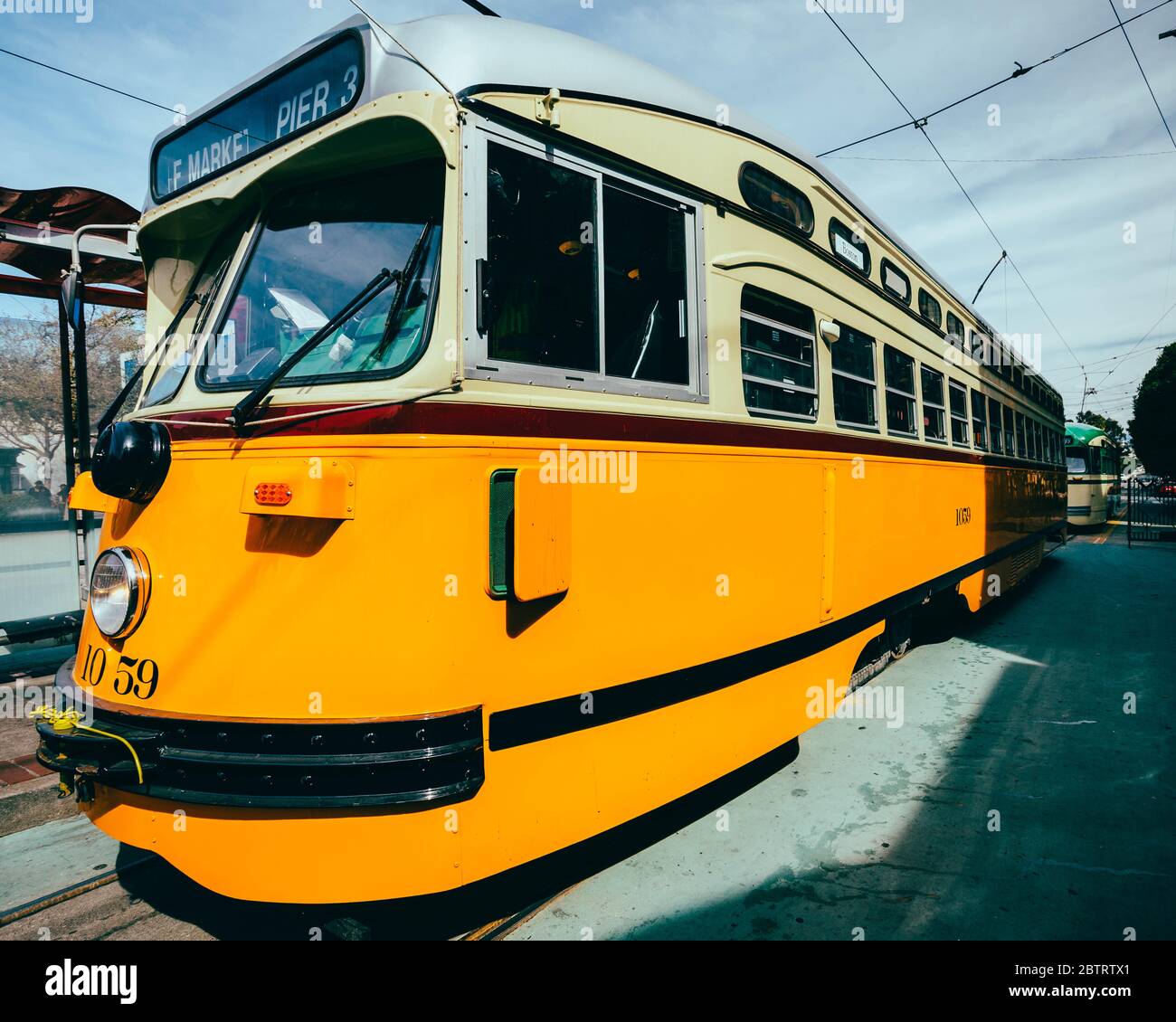 Wide angle view of a vintage orange and cream colored cable car parked ...
