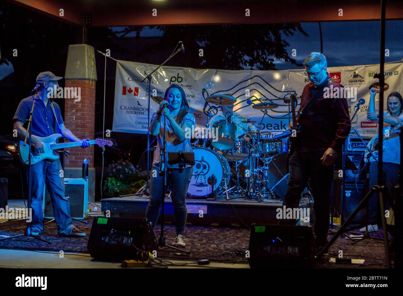 Rock band on stage, in concert. singer, bass guitar, lead guitar and ...