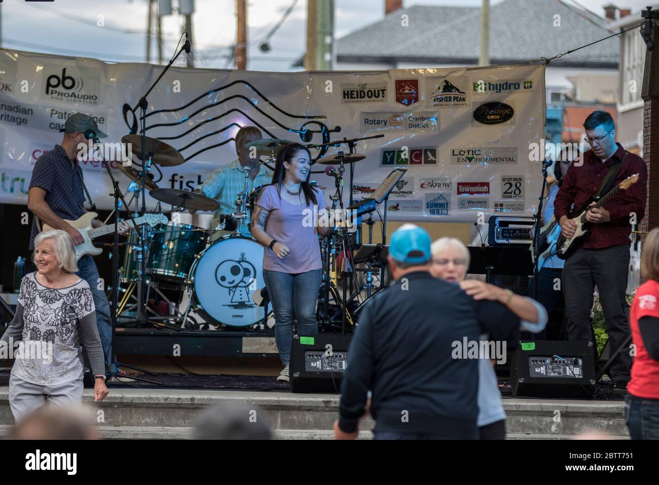 Rcok band in concert, with people dancing in forefground. Singer, bass ...