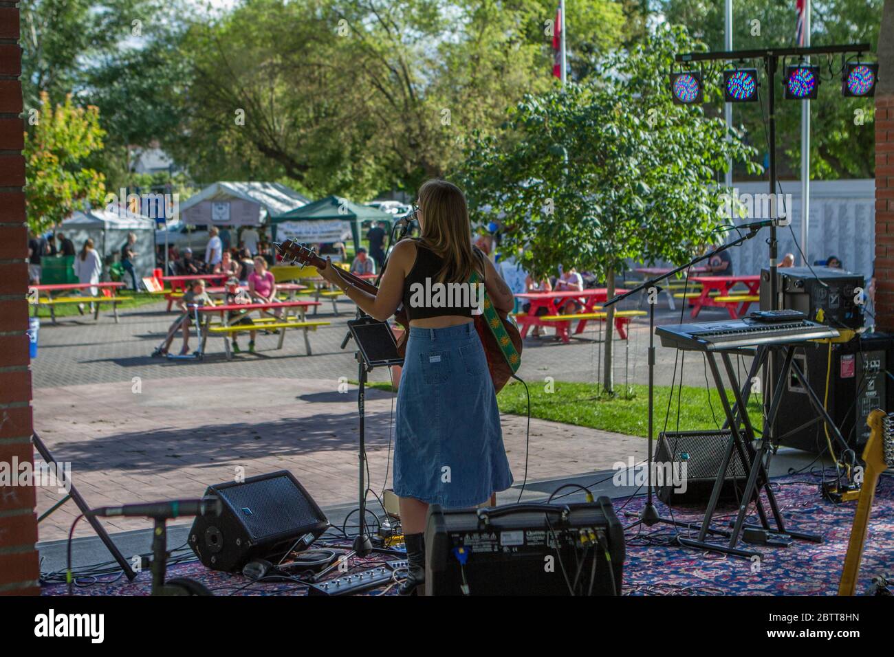 Attractive female, in outdoor concert, singing and playing keyboards ...