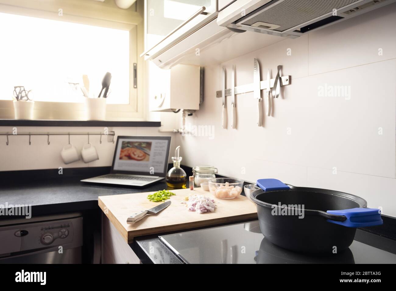 worktop of a brightly lit kitchen with cooking utensils, ingredients ...