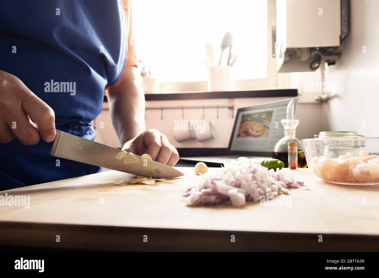 detail of the hands of a man in the kitchen chopping vegetables for the ...