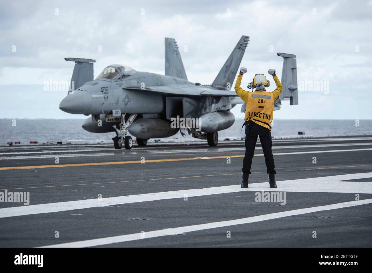 U.S. Navy Aviation Boatswain Mate Airman Shania Sullivan directs a F/A ...