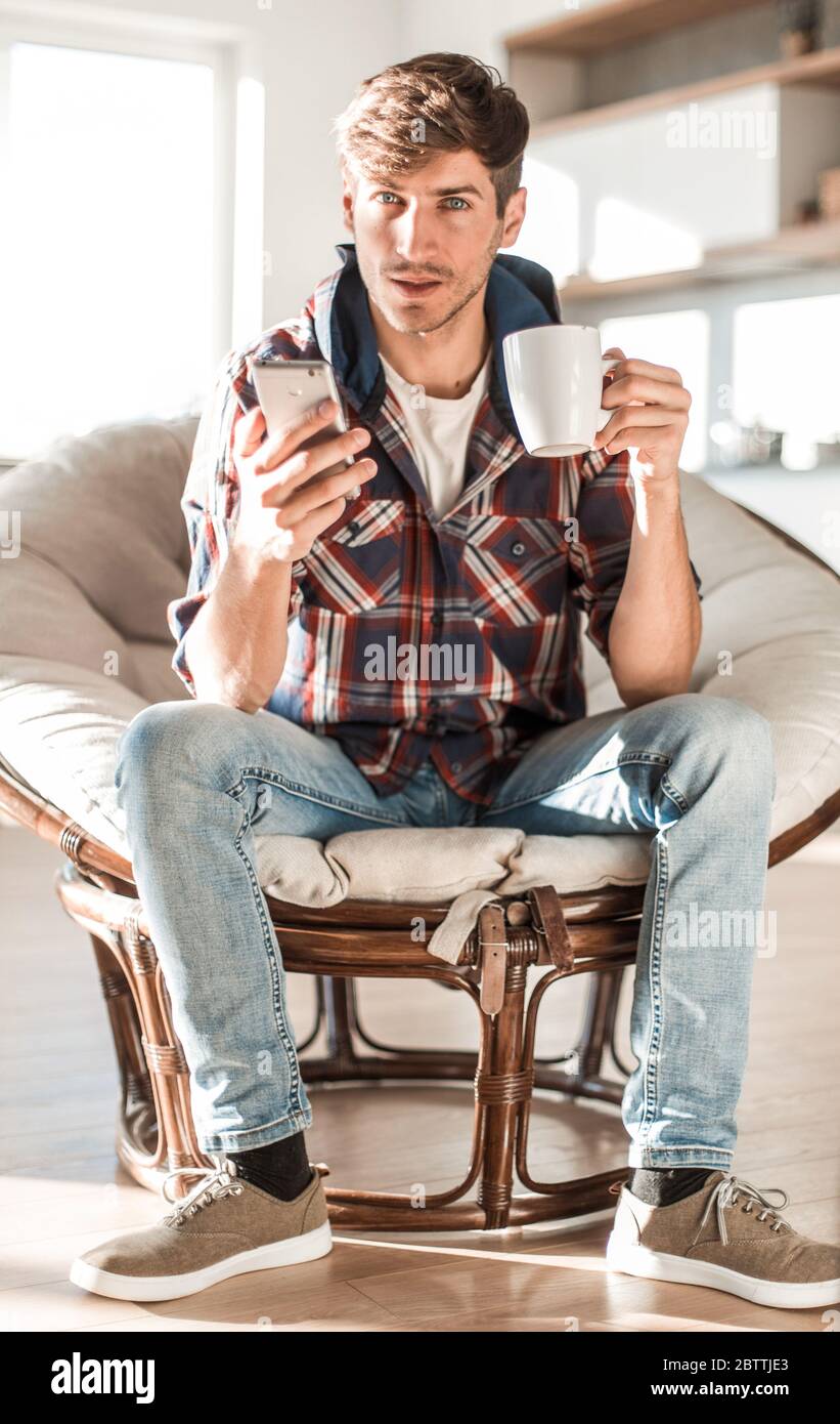 attractive guy drinks tea sitting in a comfortable chair Stock Photo ...