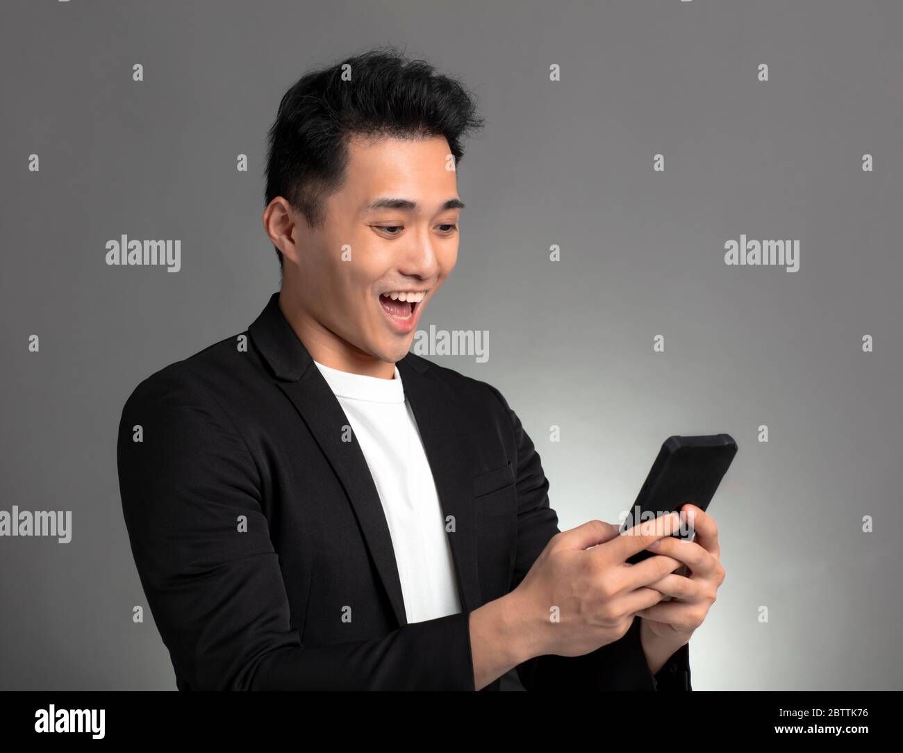 Surprised young business man watching the mobile phone Stock Photo - Alamy