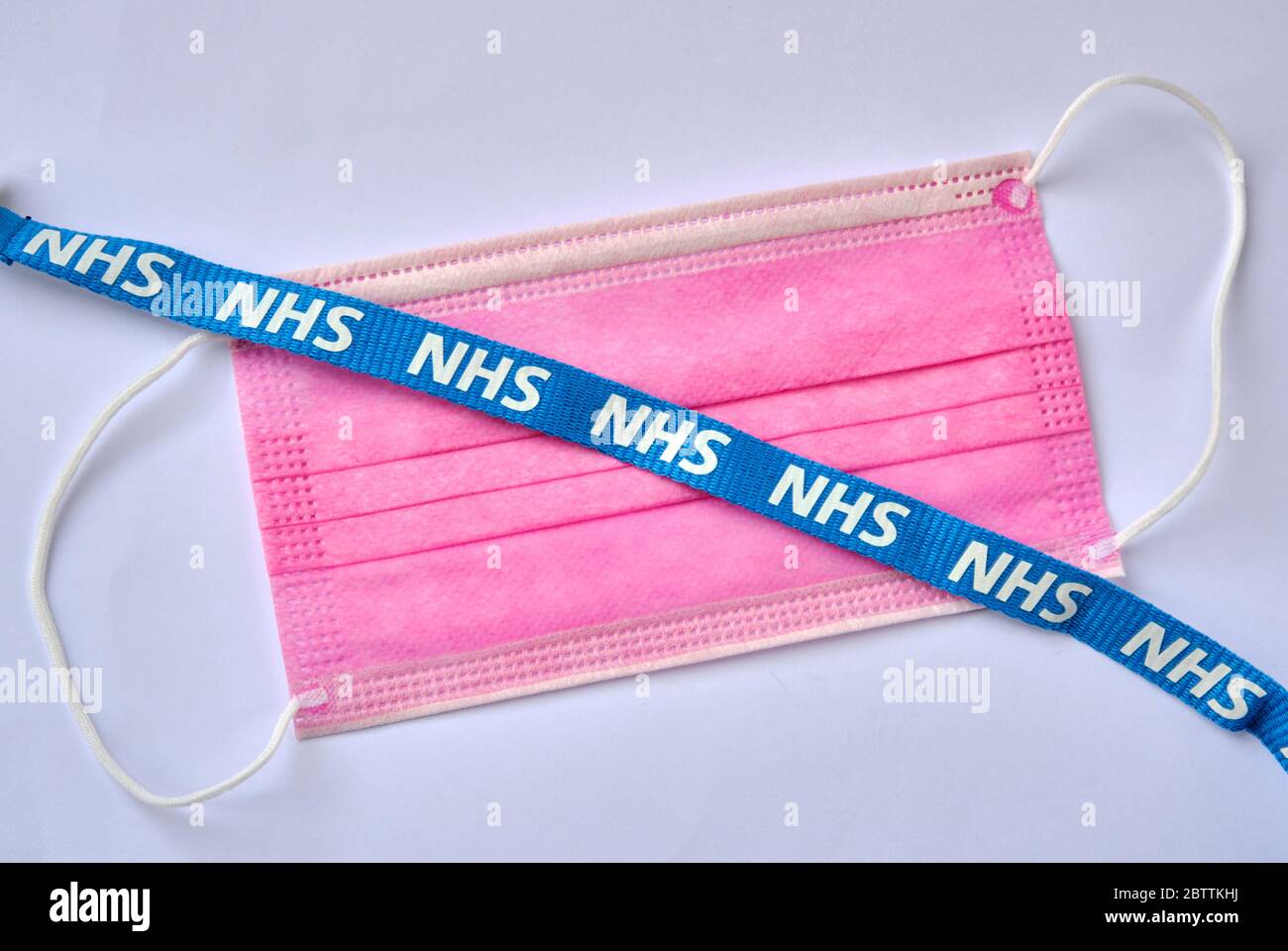 Large NHS letters seen on the blue lanyard which is placed on top of a ...