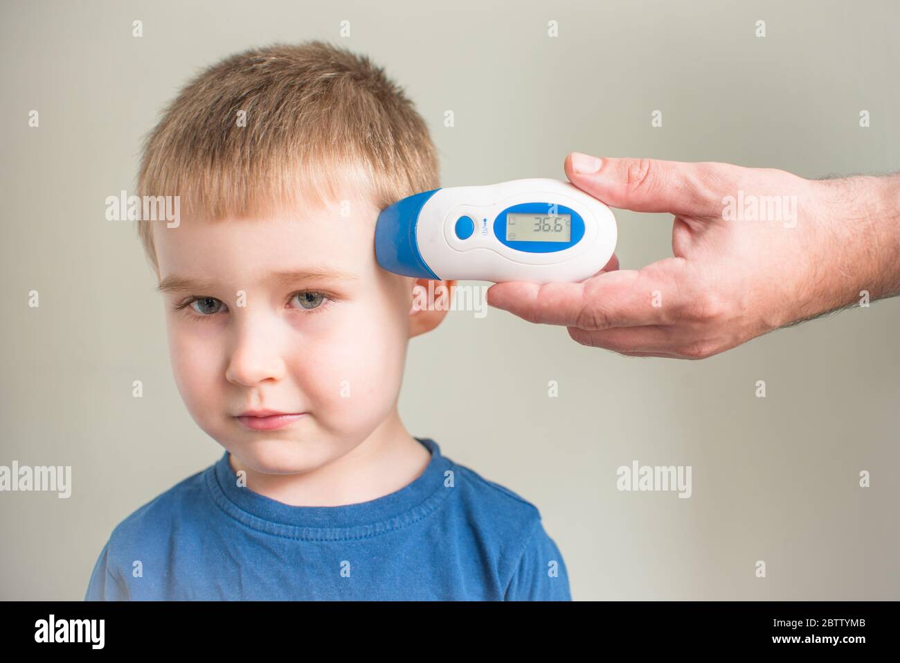 Man checks boy's body temperature using digital thermometer for virus ...