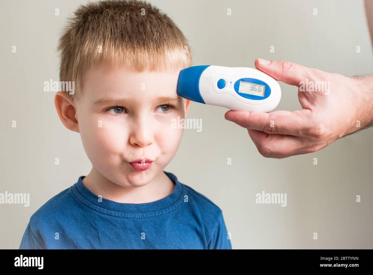 Man checks boy's body temperature using digital thermometer for virus ...