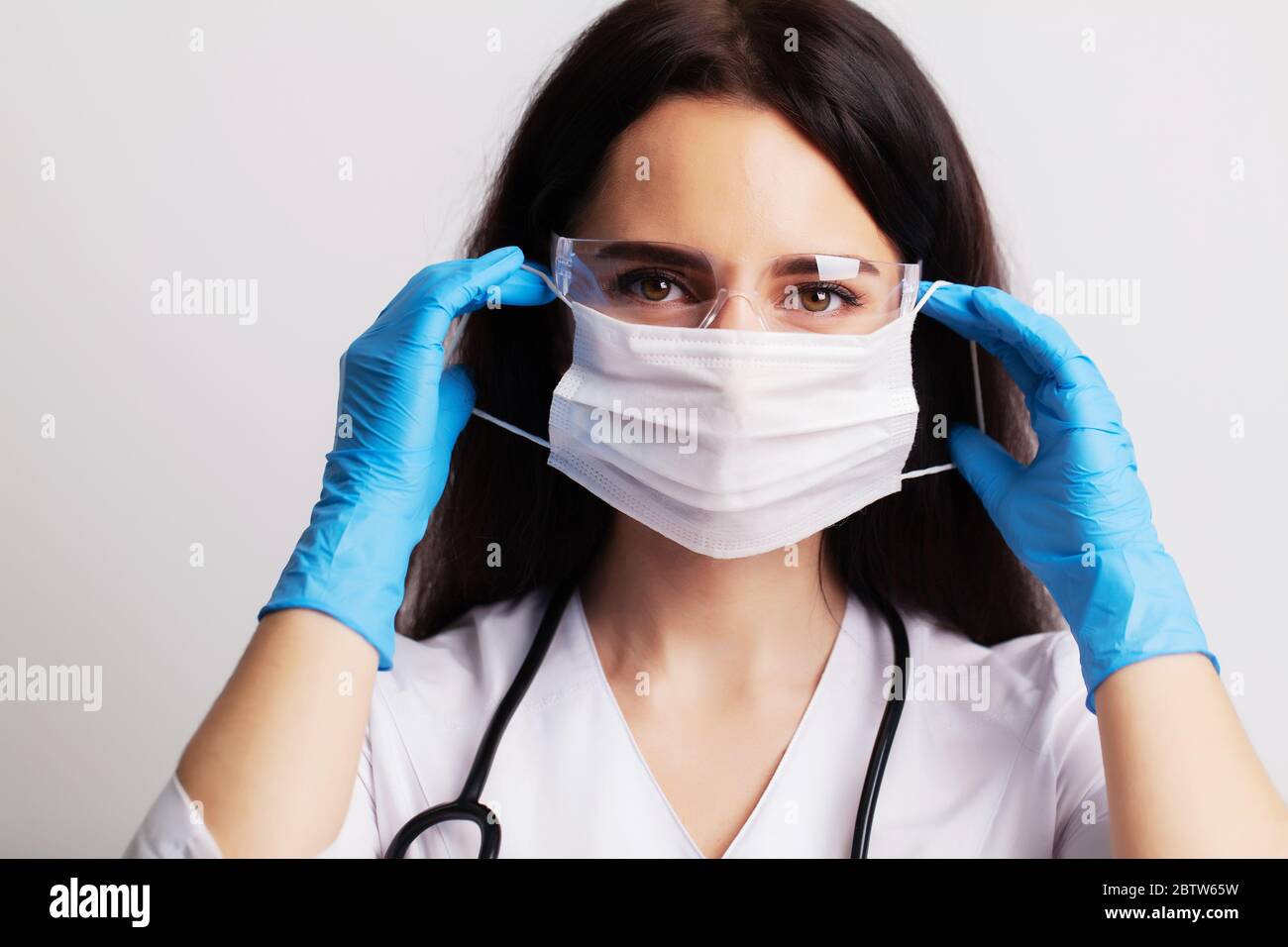 Medicine concept, doctor puts on protective surgical mask for ...