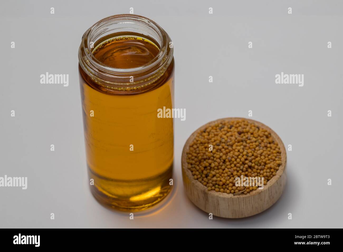 Close-up view of raw mustard and mustard oil on white background Stock ...