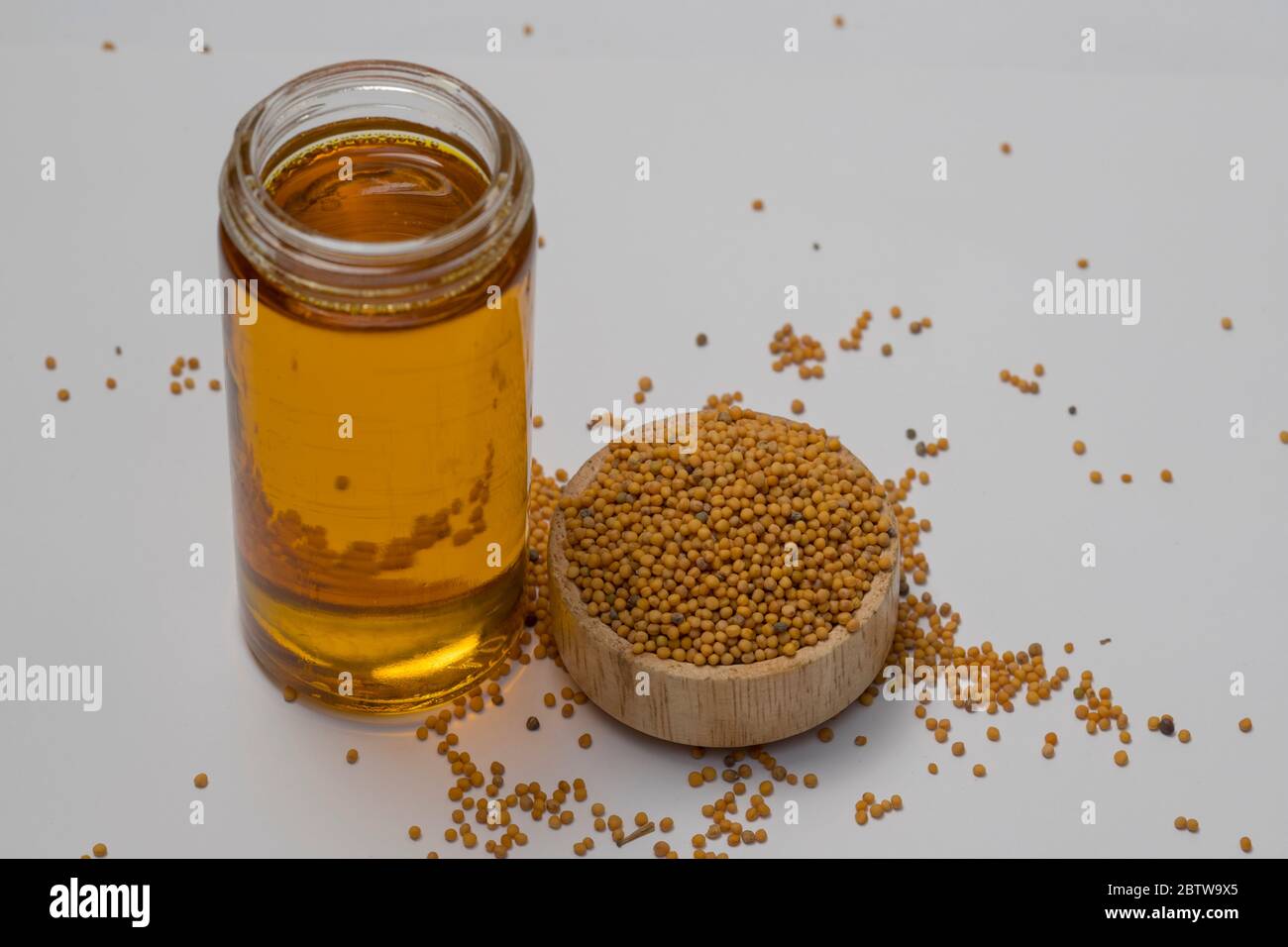 Close-up view of raw mustard and mustard oil on white background Stock ...