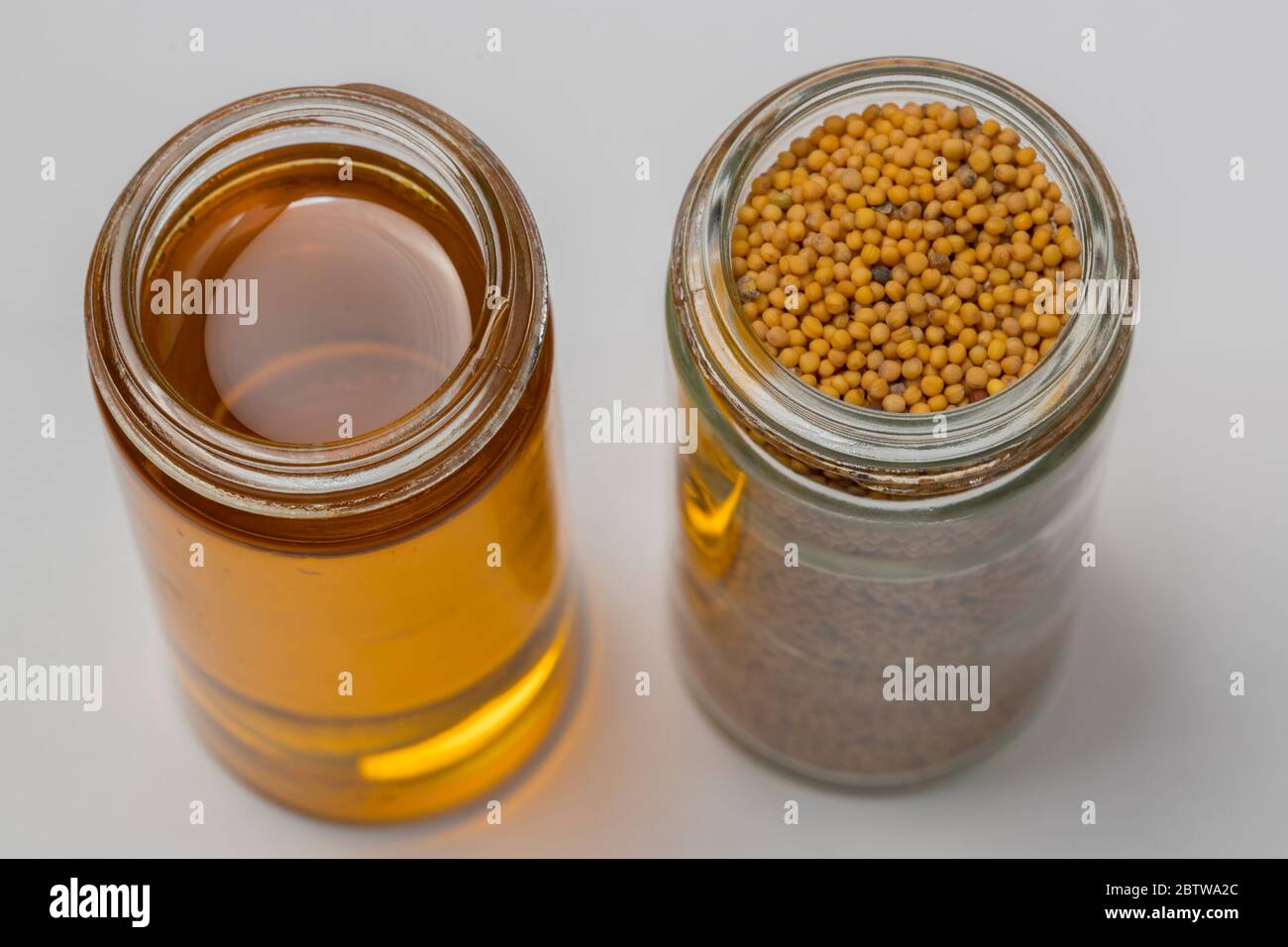 Close-up view of raw mustard and mustard oil on white background Stock ...