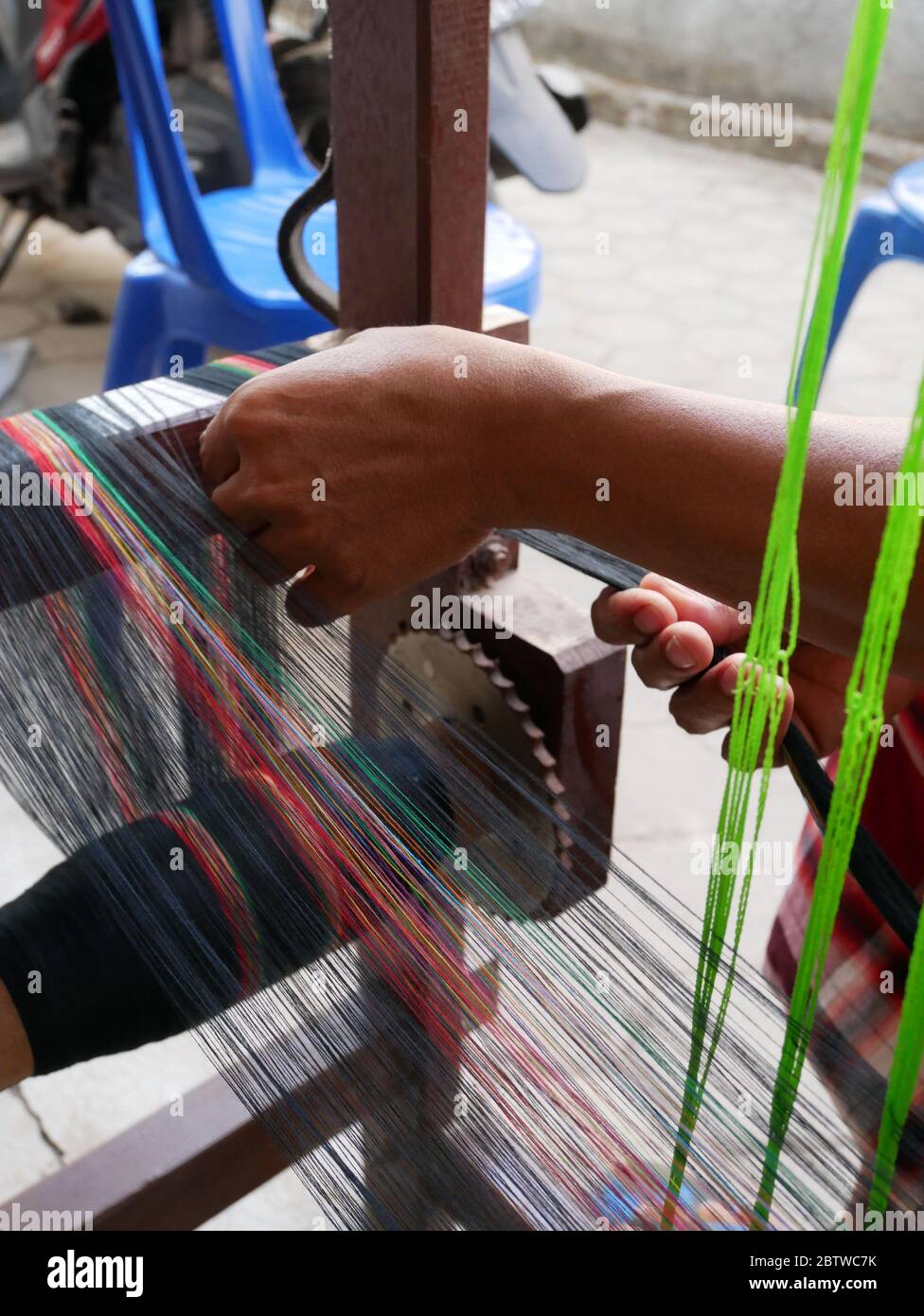 View of the hands of a weaver arranging cotton threads on a mechanical ...