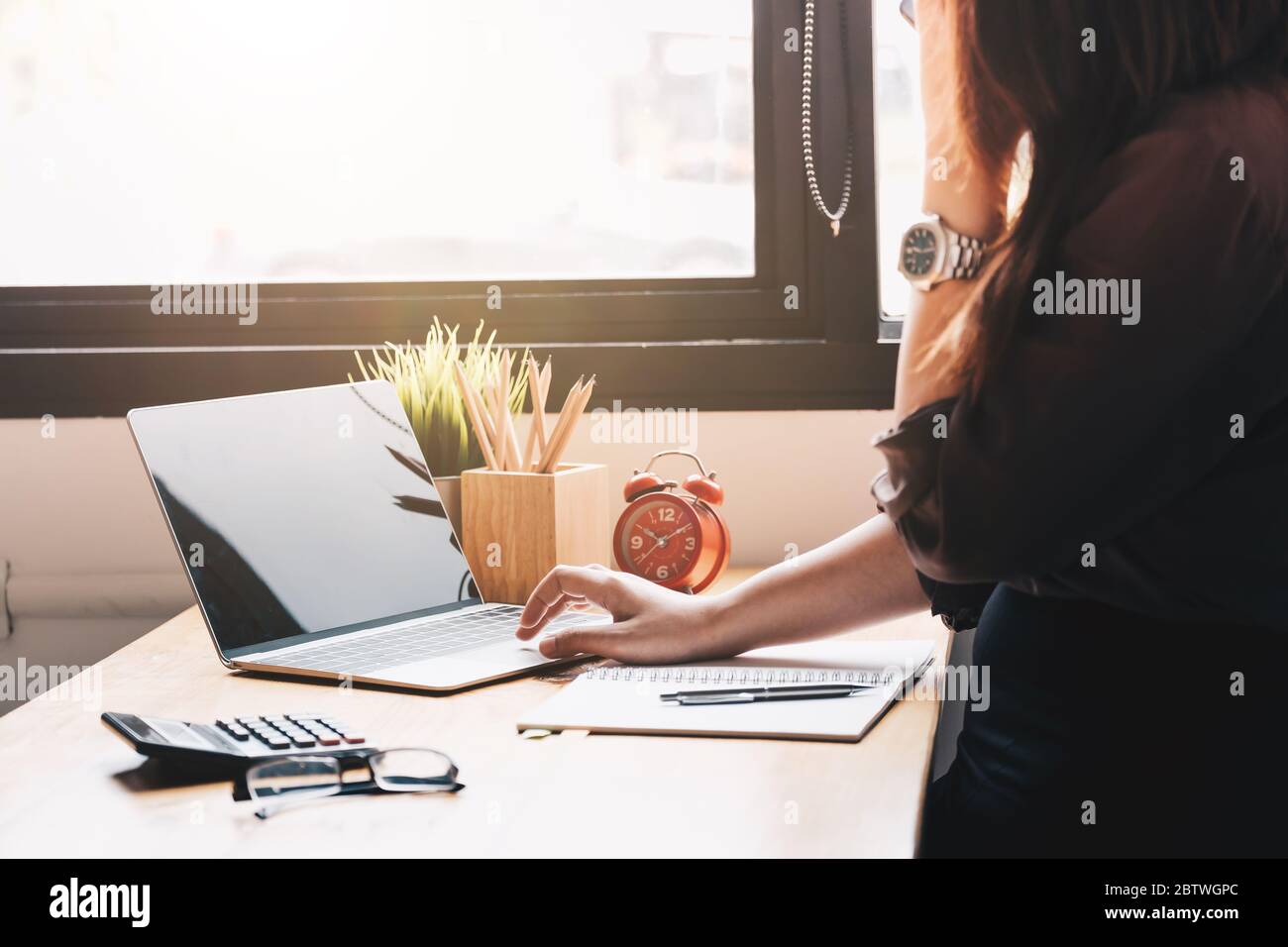 female accountant using calculator and typing on laptop Stock Photo - Alamy