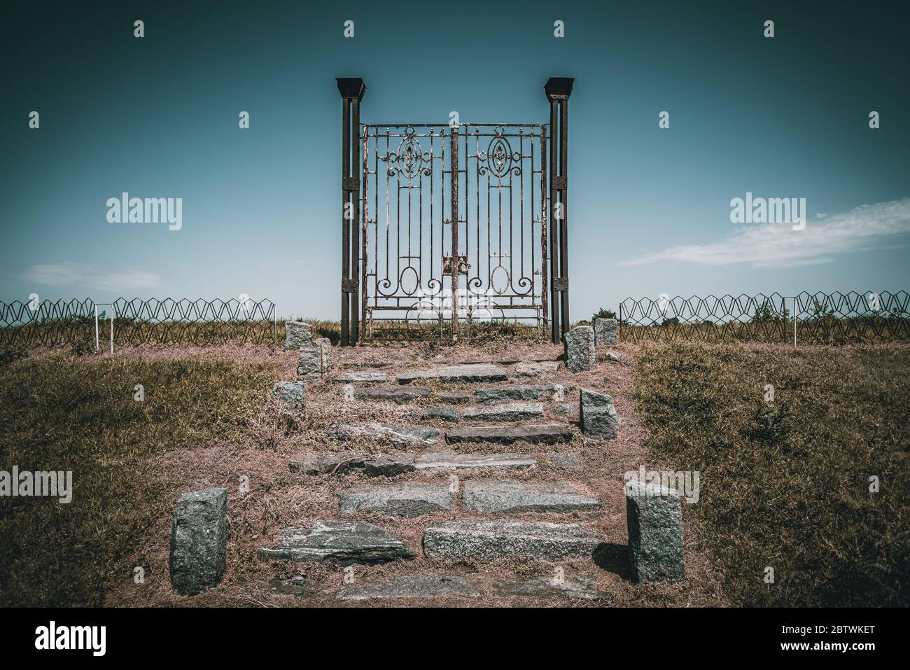 Old rusty iron gate in the middle of a field leading to nowhere ...