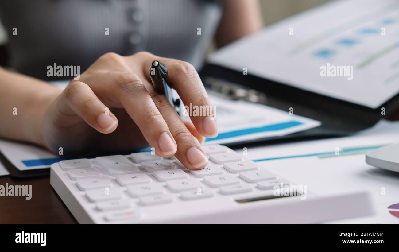 Close up accountant banker or bookkeeper making calculations with ...