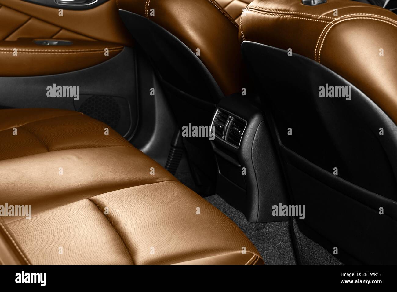 Back passenger brown seats in modern luxury car. Orange perforated ...