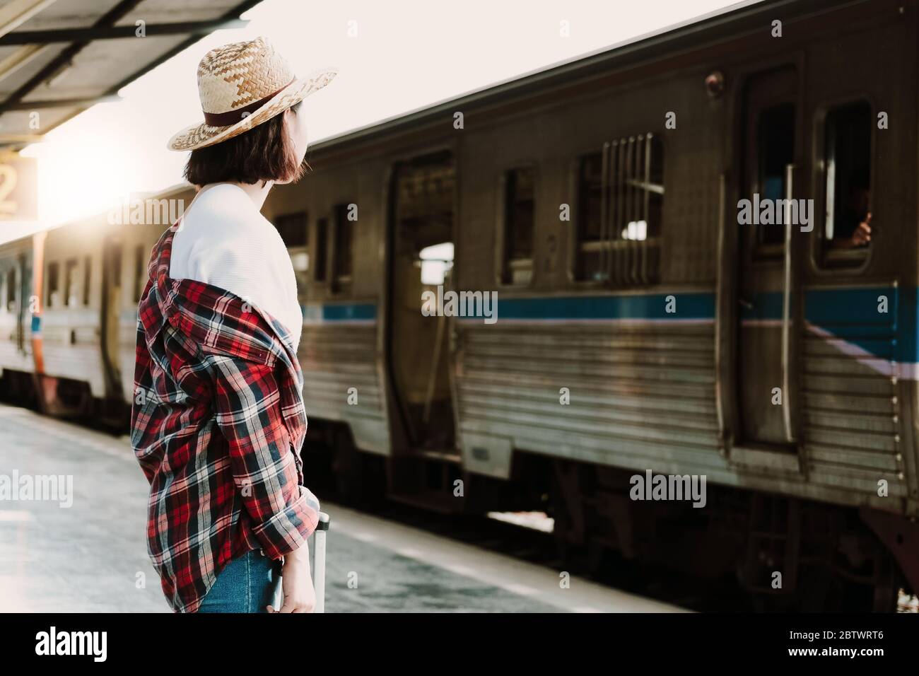 Pretty woman waiting the train at train station for travel in summer ...