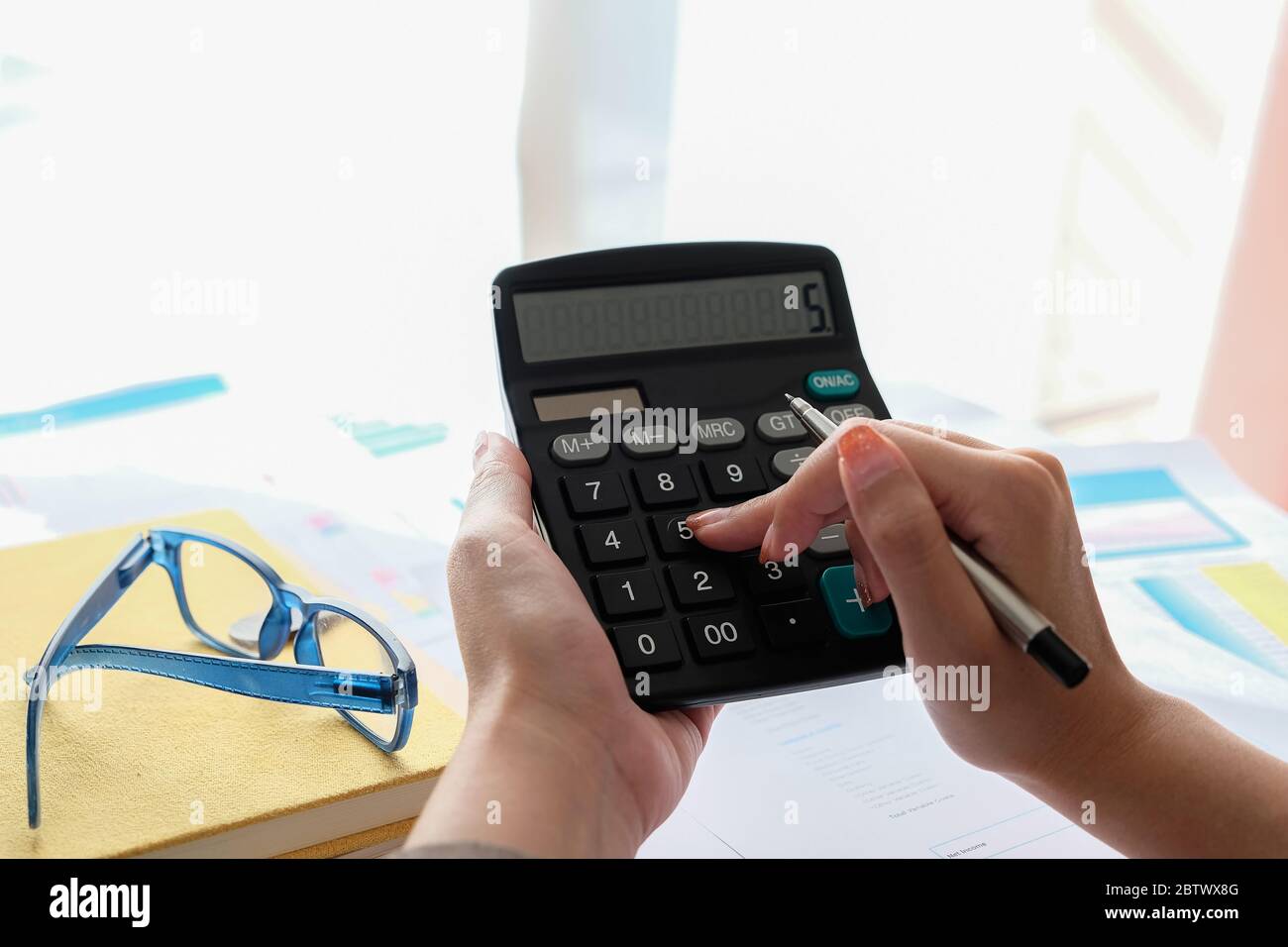 Close up Accountant using calculator for calculating financial expense ...