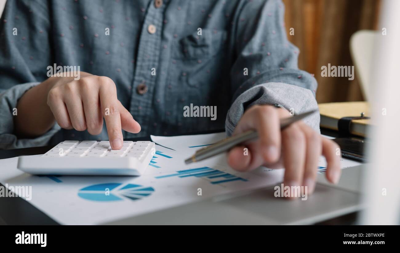 Business woman or accountant working on calculator and laptop computer ...