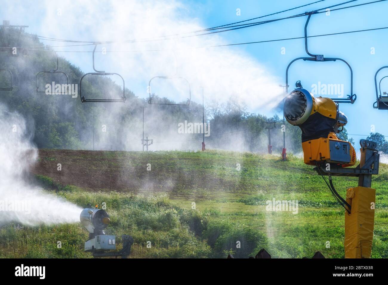 Snow gun in the summer in the mountain ski resort. A hillside snowmaker ...