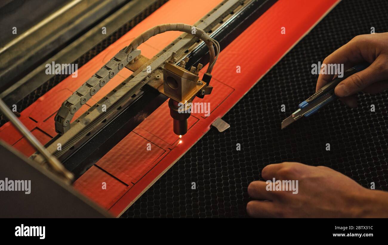 Laser cutting beam high precision on a paperboard. Modern machine ...