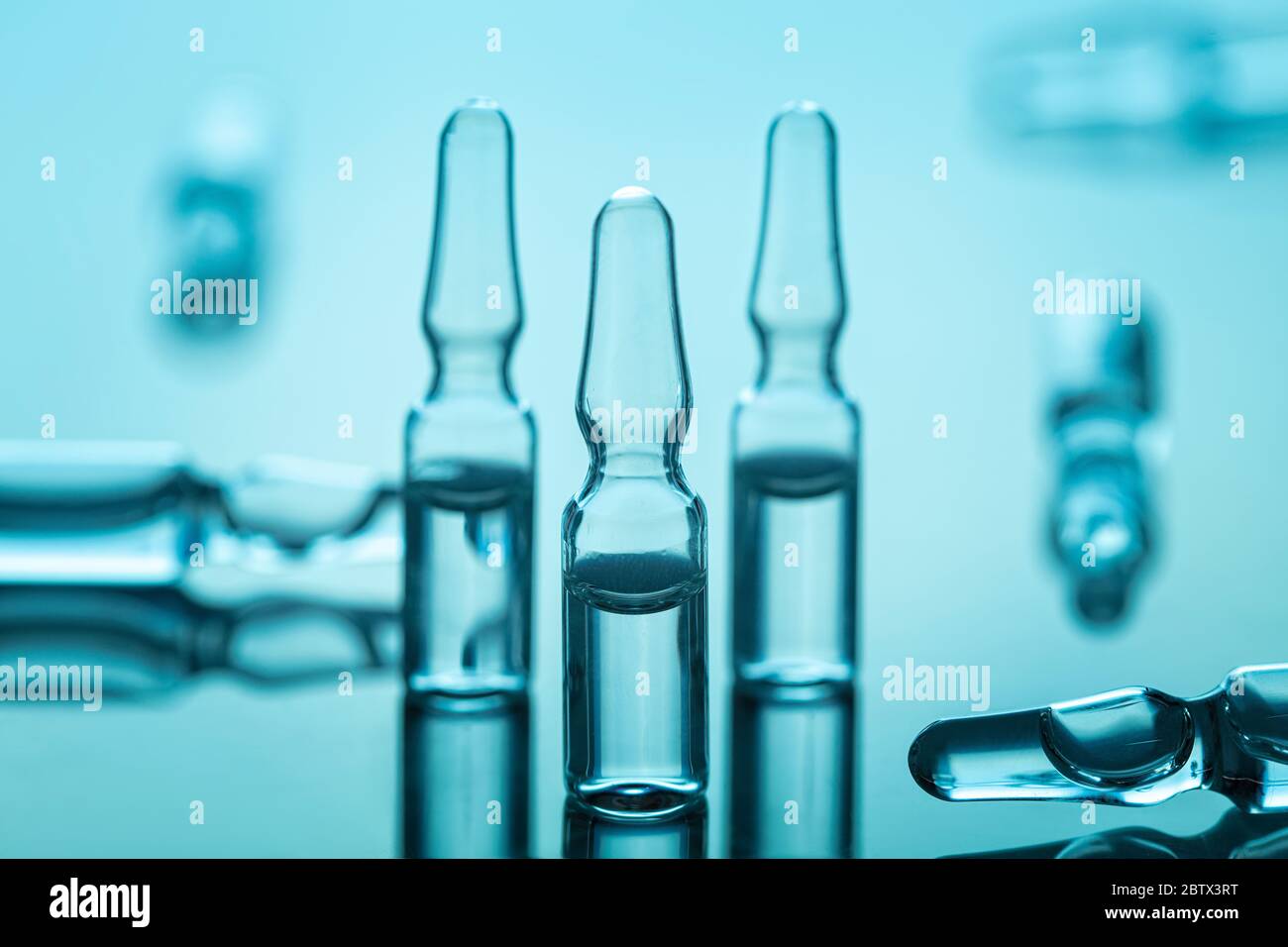 Medical glass ampules on blue background Stock Photo - Alamy