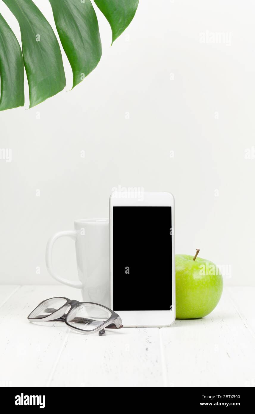 Office workplace desk table with smartphone, apple and coffee cup over ...