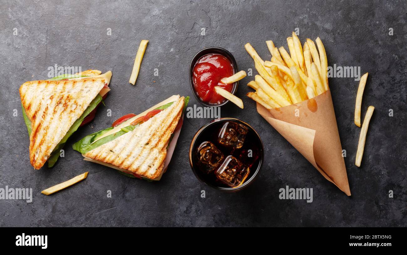 Club sandwich, potato fries chips and glass of cola drink with ice ...