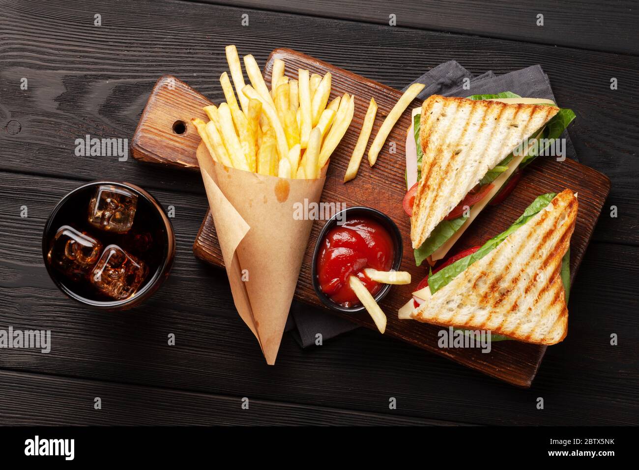 Club sandwich, potato fries chips and glass of cola drink with ice ...