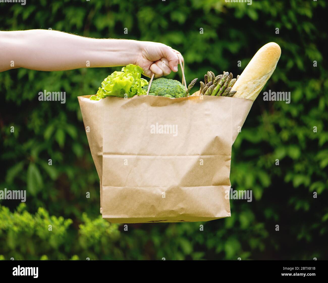 Hand holding brown paper bag hi-res stock photography and images - Alamy