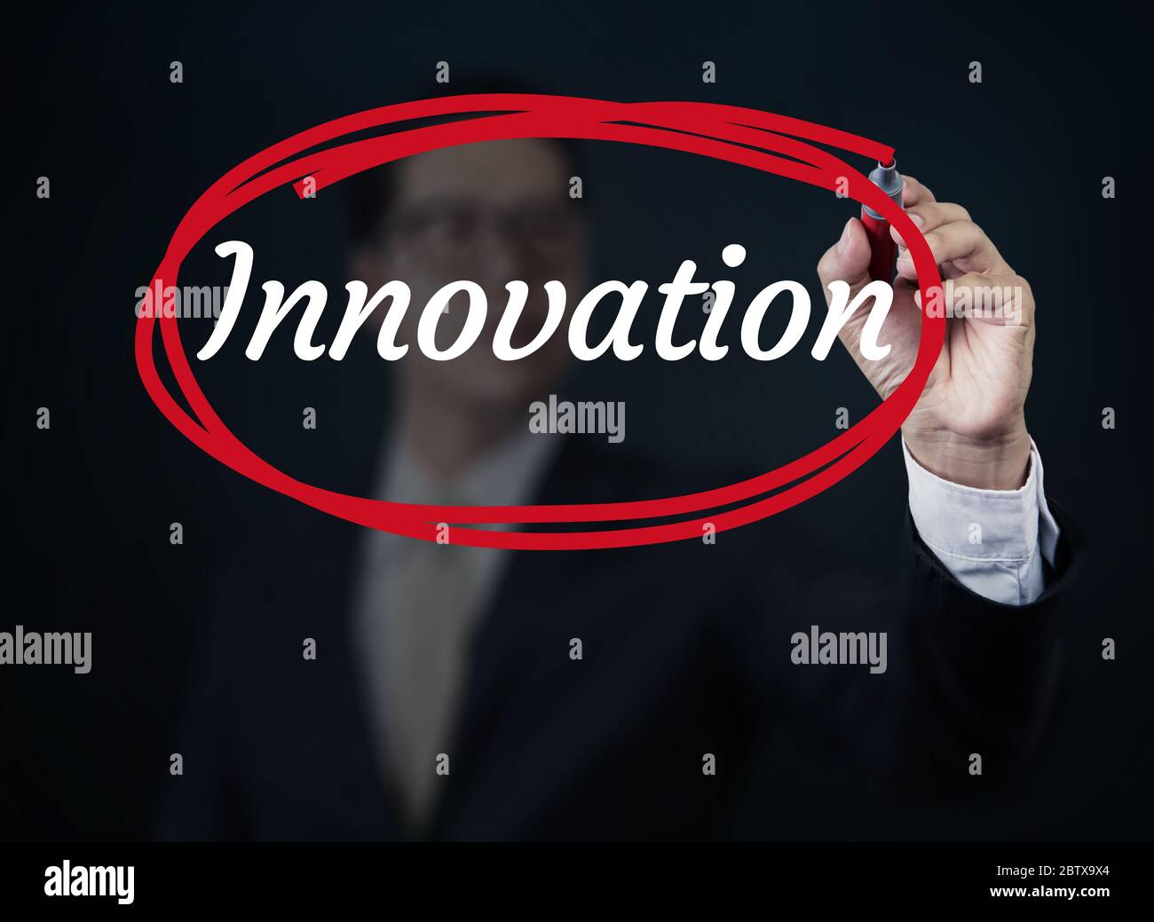 Businessman hand writing "Innovation" with red marker on transparent ...