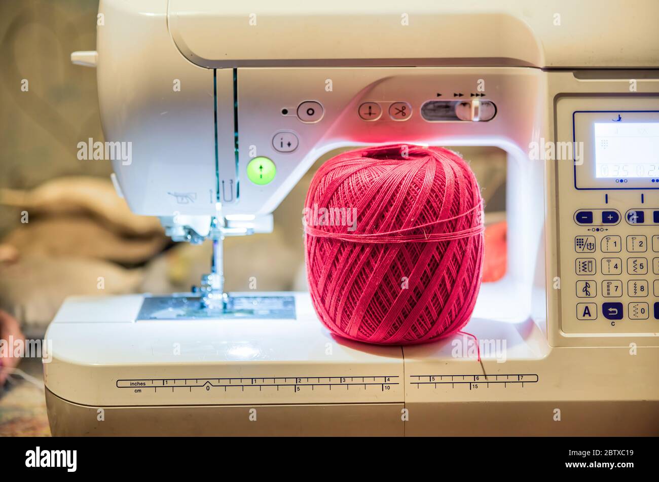Red color ball of threads wool under sewing machine Stock Photo - Alamy