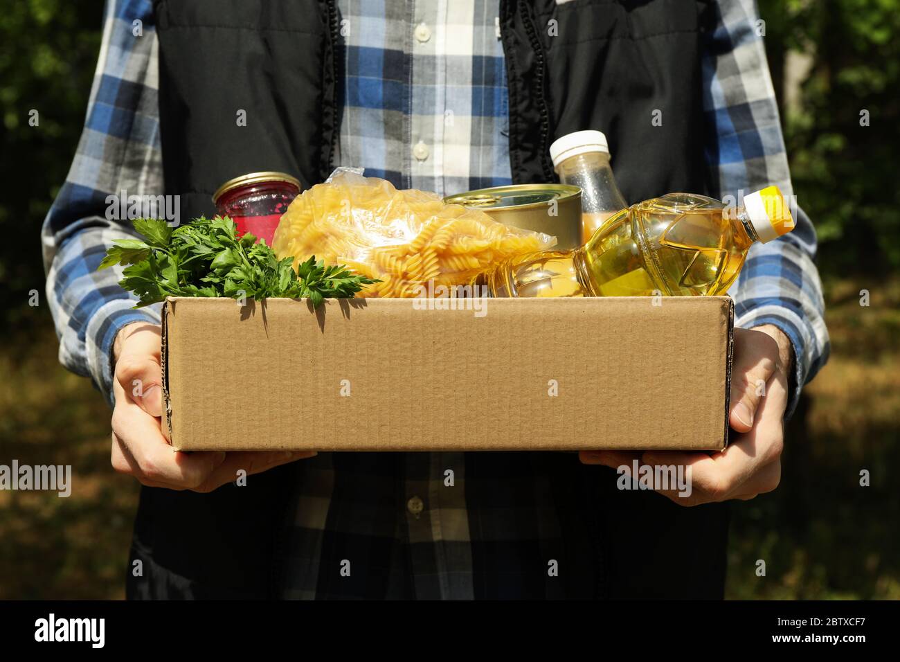 Man holds donation paper box outdoor. Volunteer Stock Photo - Alamy