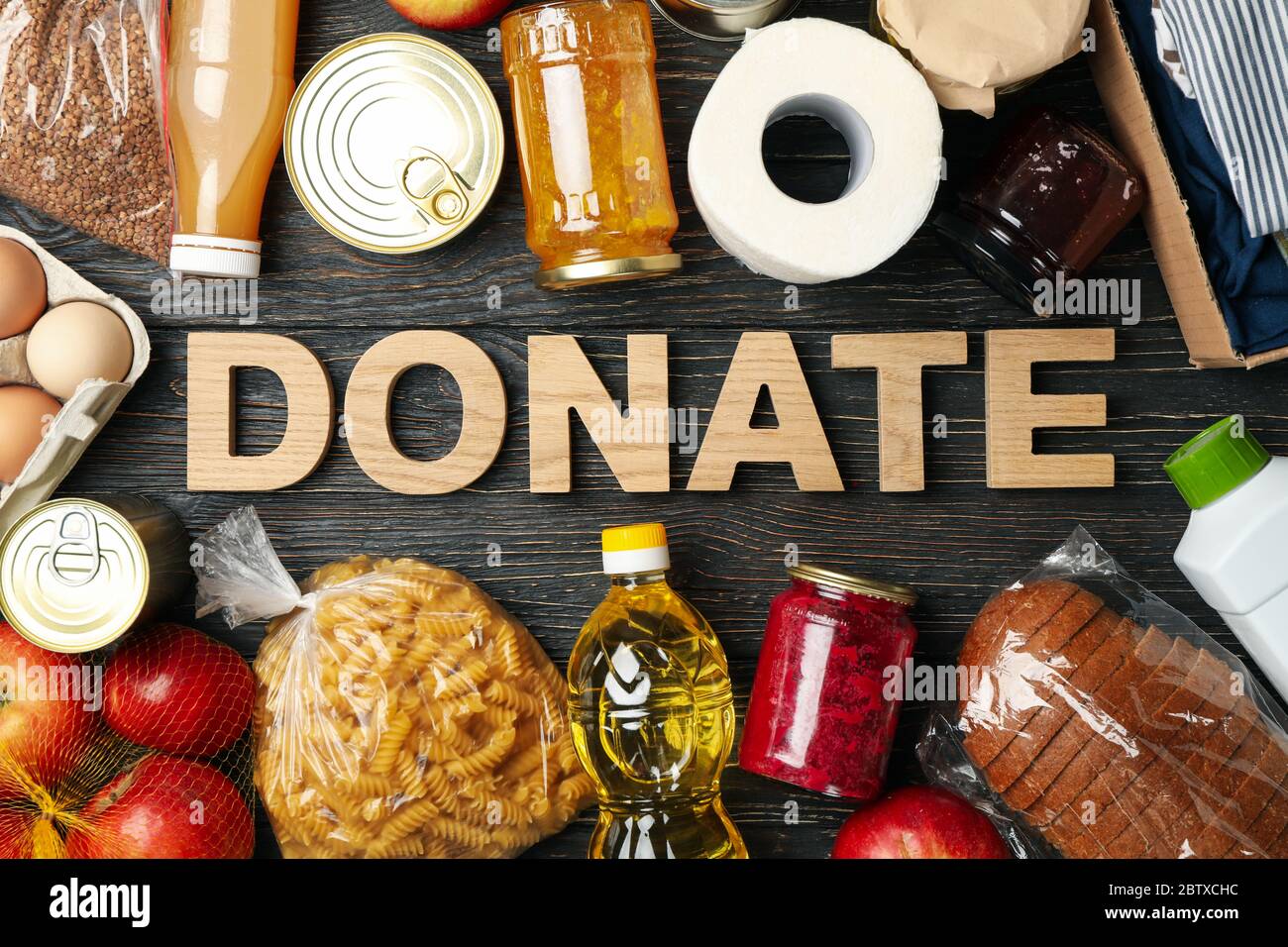 Different food and text Donate on wooden background, top view. Donation ...