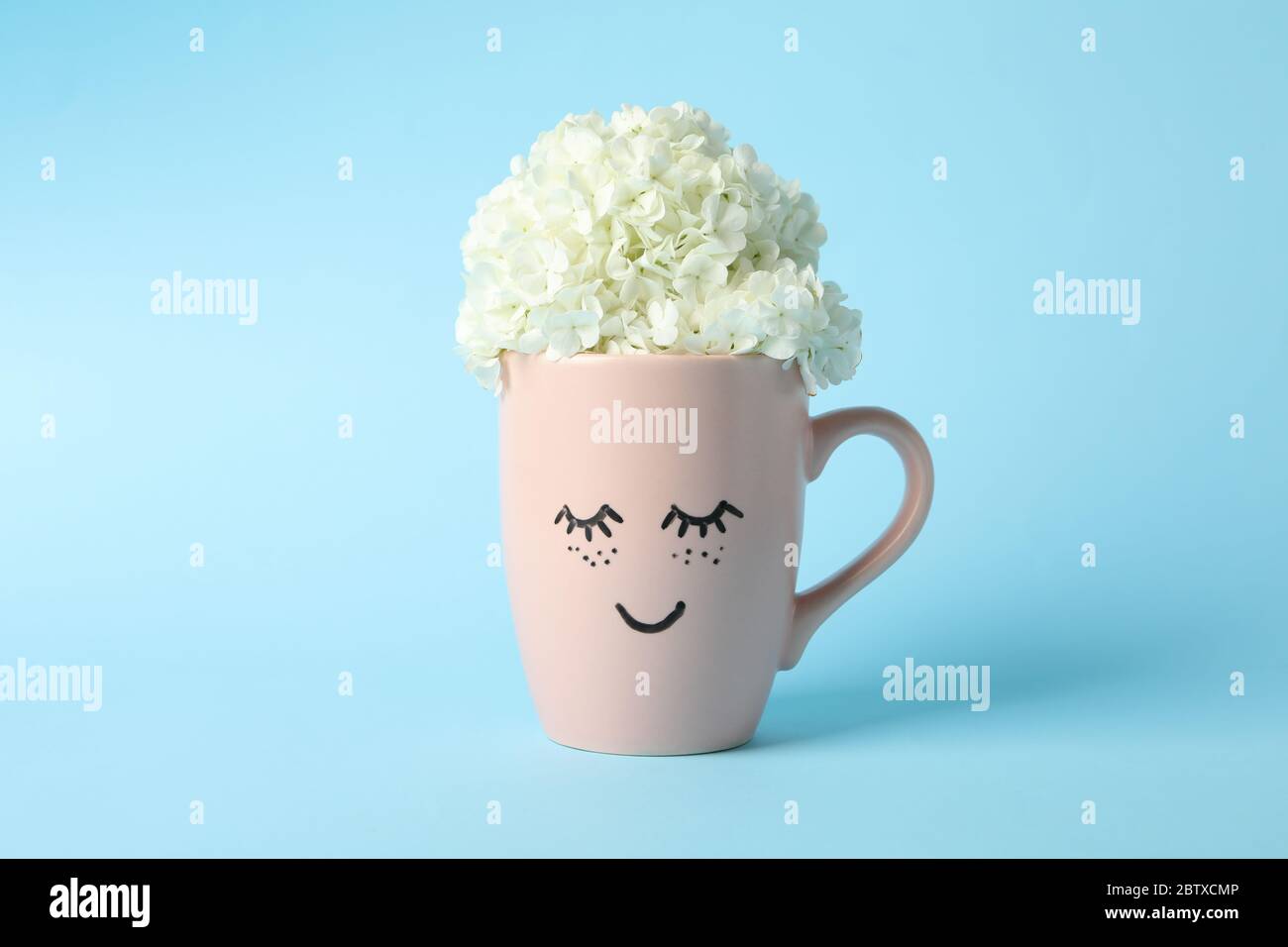 Cup with hydrangea flowers on blue background. Spring plant Stock Photo ...