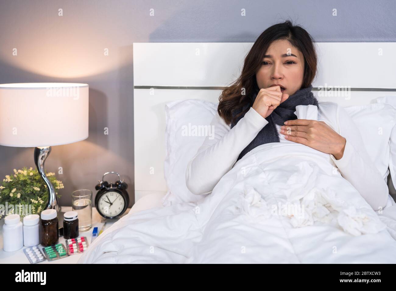 sick woman feeling cold and coughing in a bed Stock Photo - Alamy
