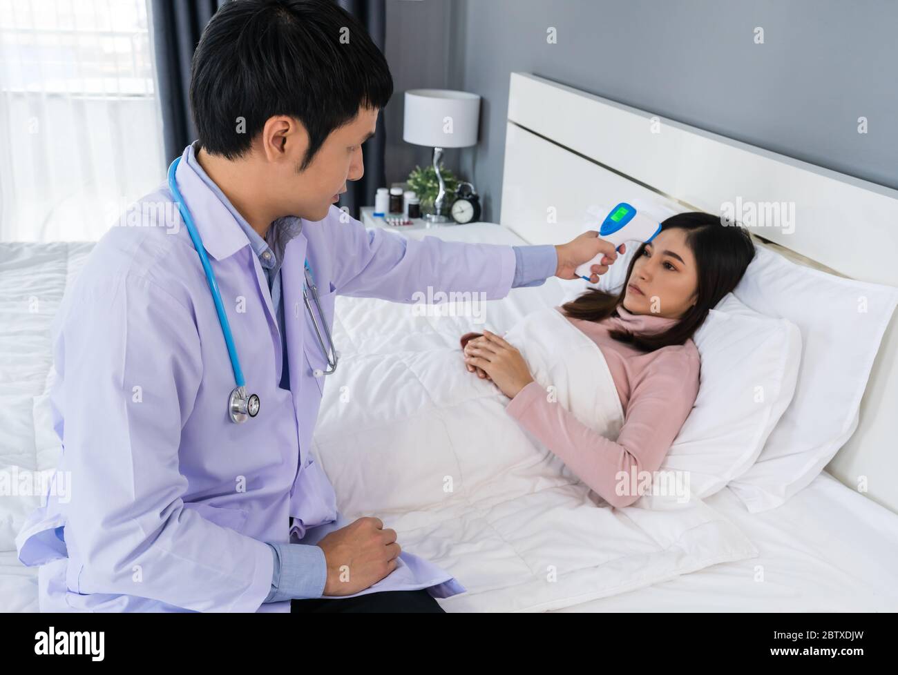 doctor using infrared forehead thermometer (thermometer gun) to ...