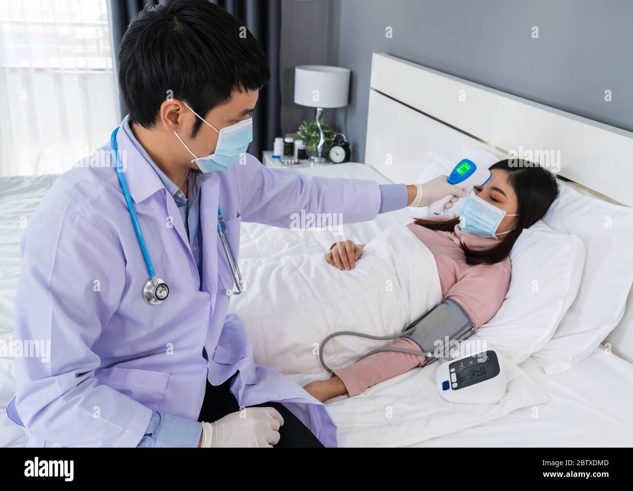 doctor using infrared forehead thermometer (thermometer gun) to ...