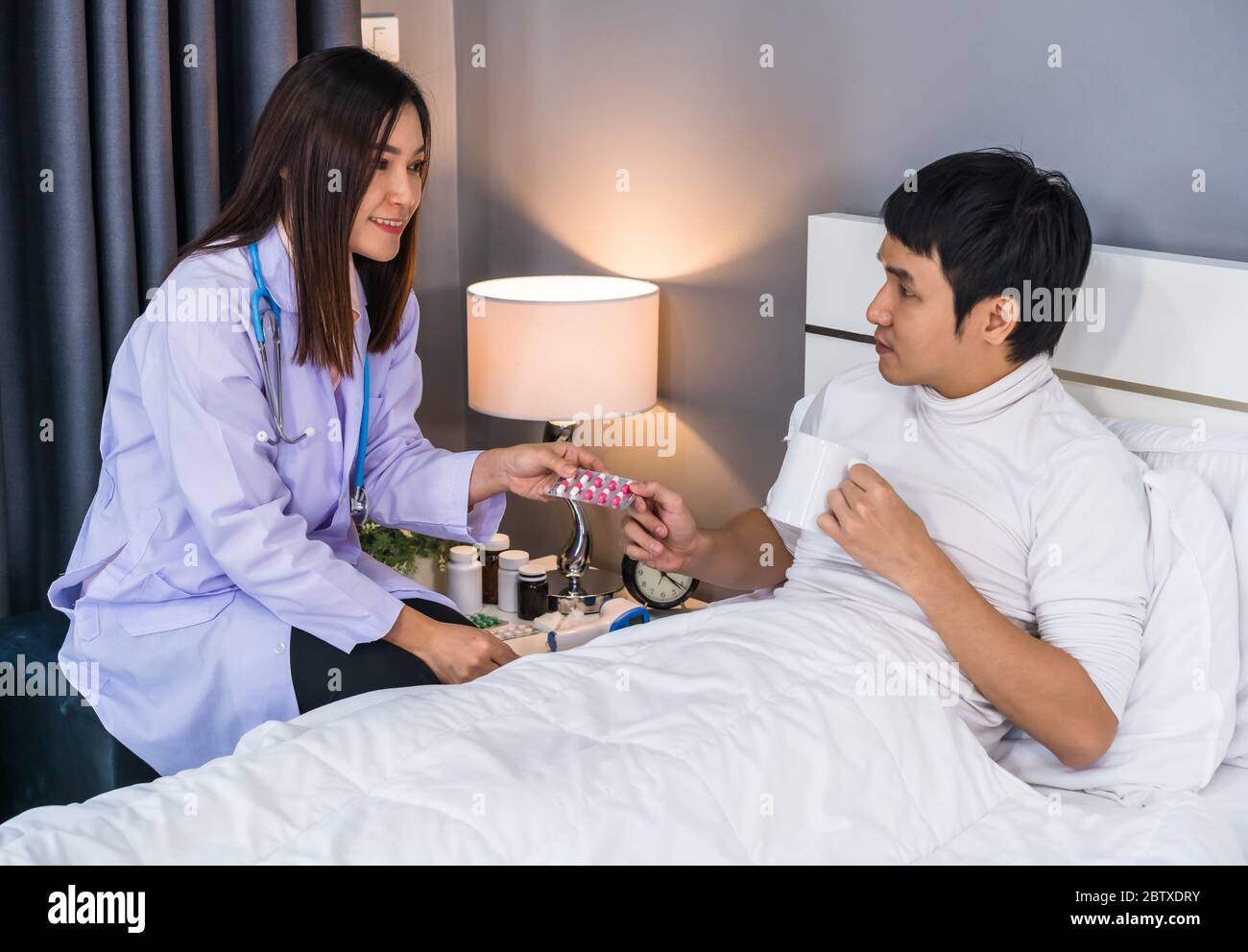 Doctor explaining the pills to male patient in a bed Stock Photo - Alamy