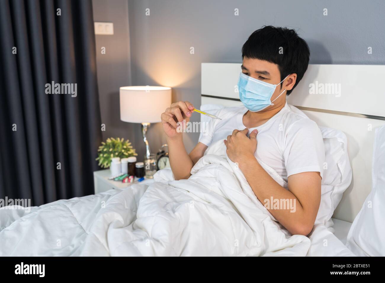 sick man in medical mask using thermometer to checking his temperature ...