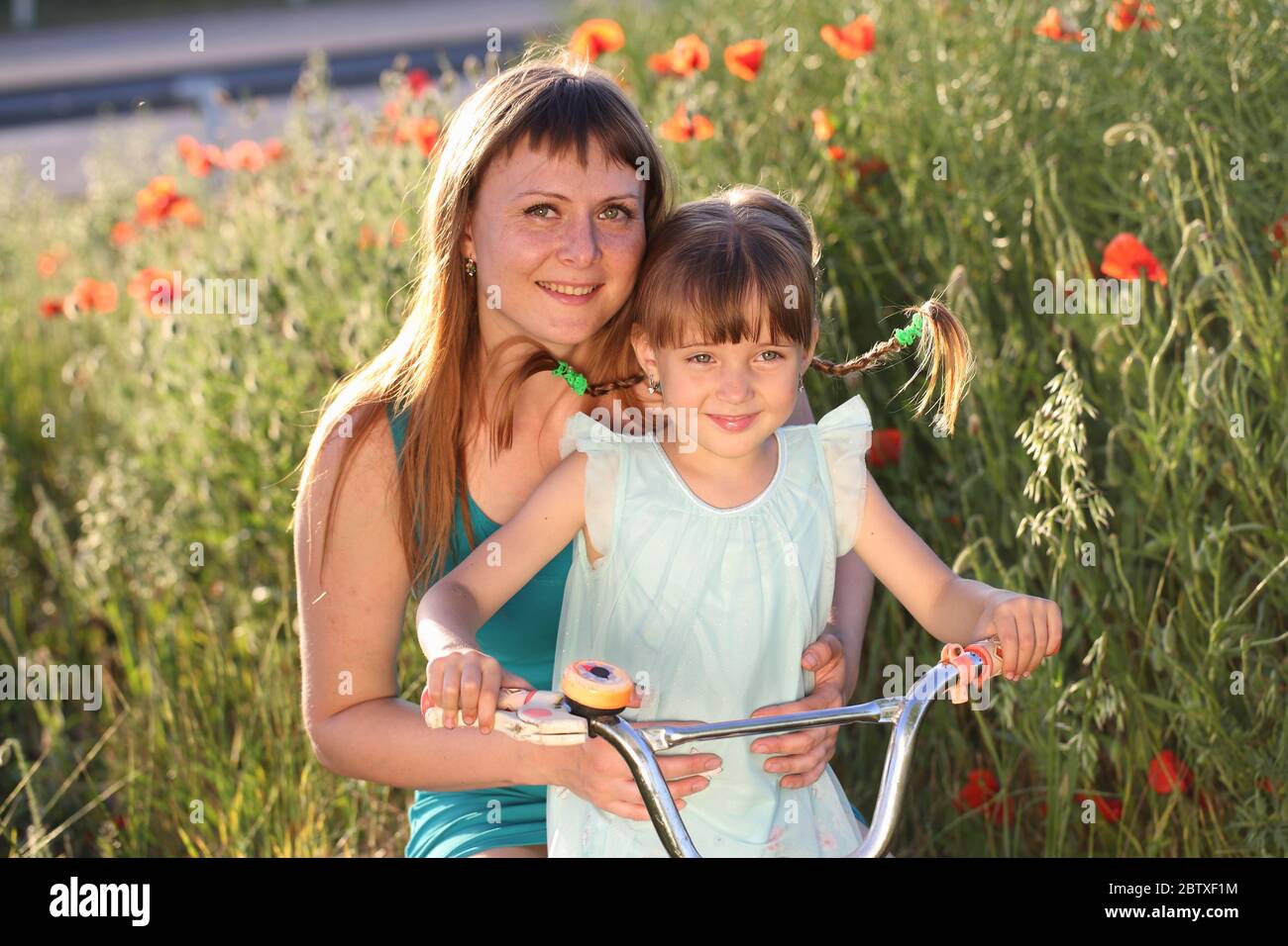 Mom with daughter on a bicycle Stock Photo - Alamy