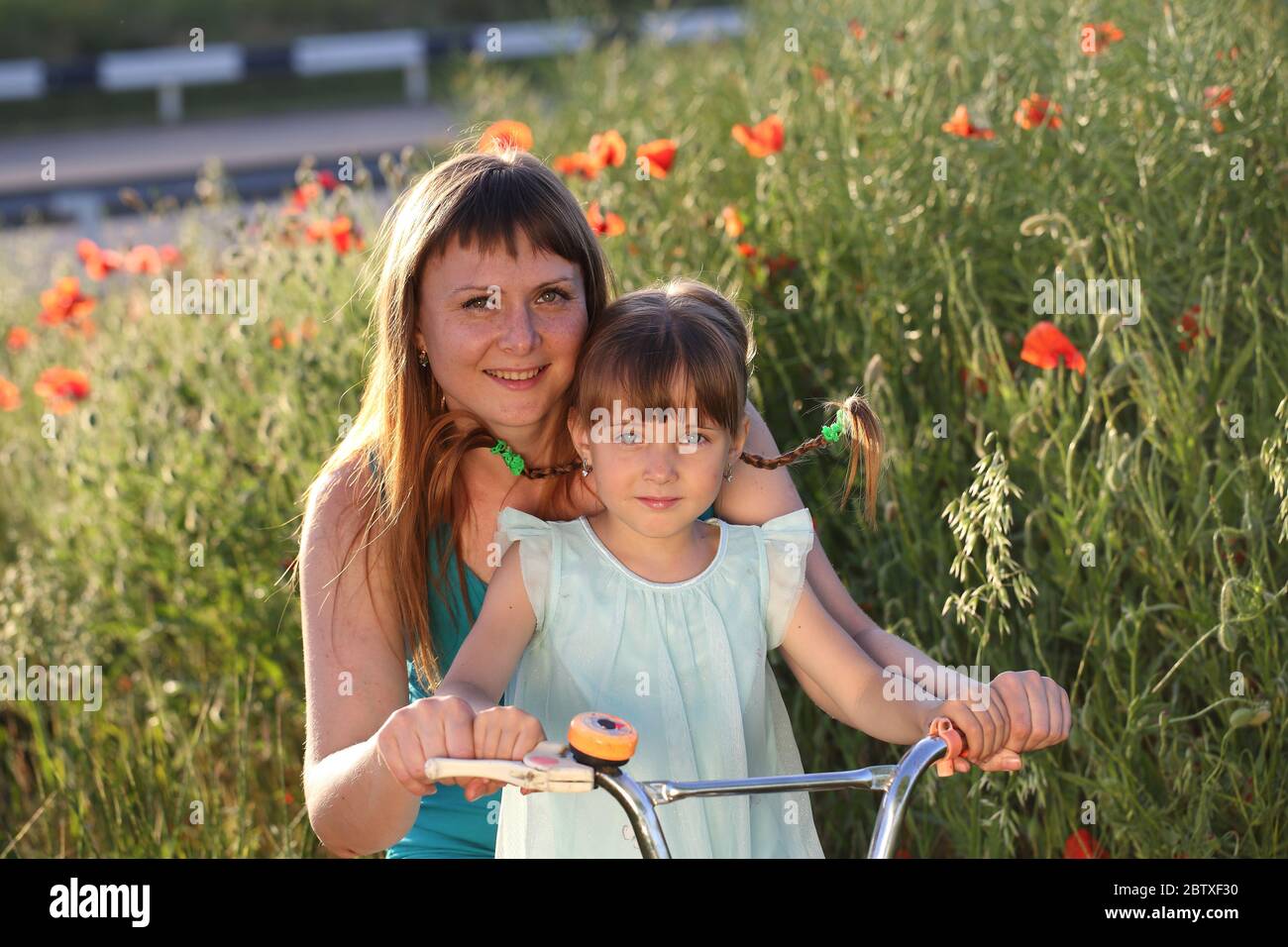 Mom with daughter on a bicycle Stock Photo - Alamy