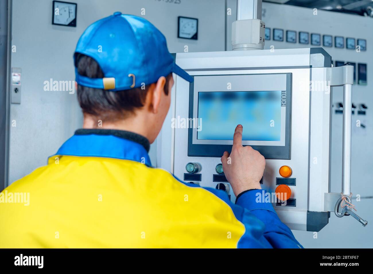 Man worker in manufacturing plant at cable factory machine control ...